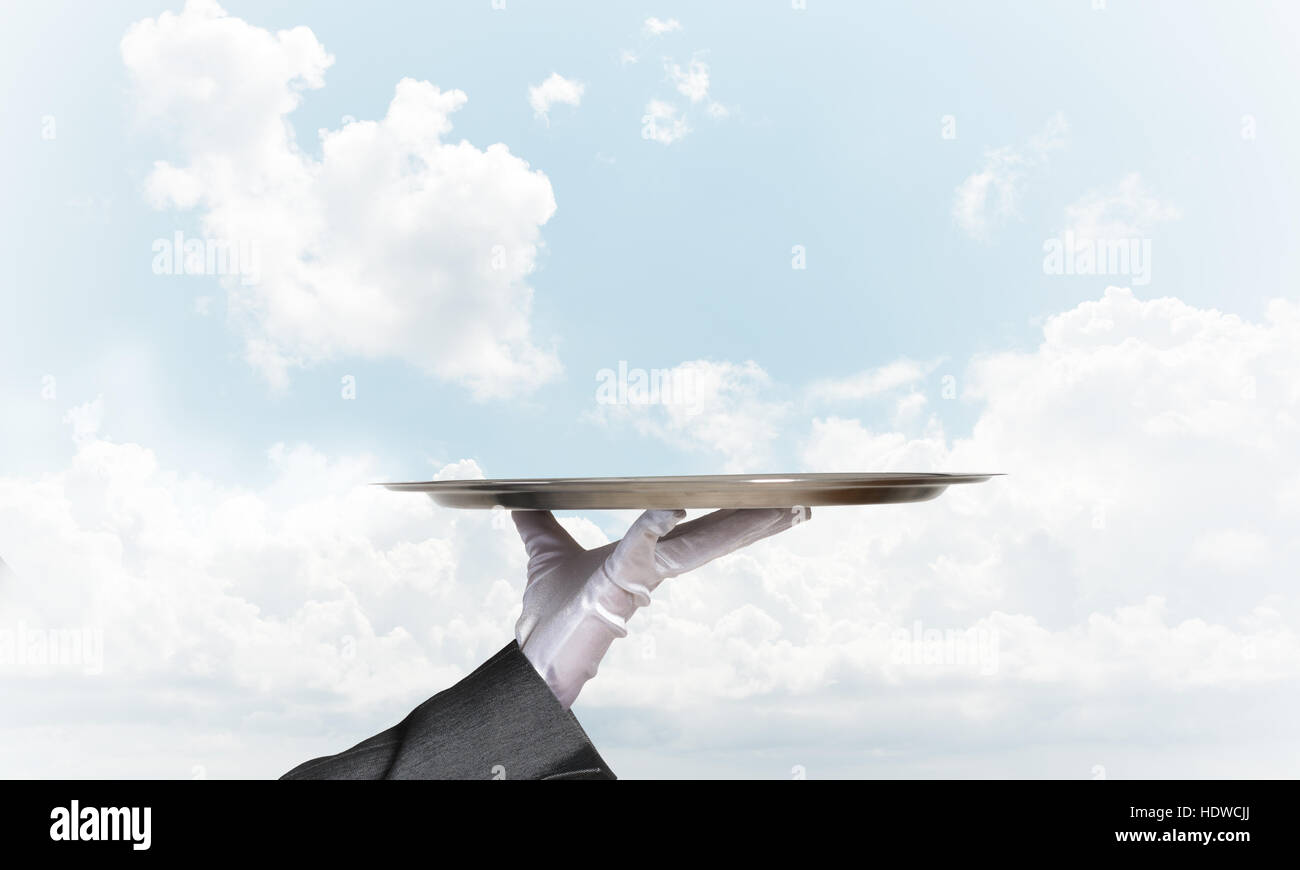Waiter holding empty silver platter ready for product or item placement ...