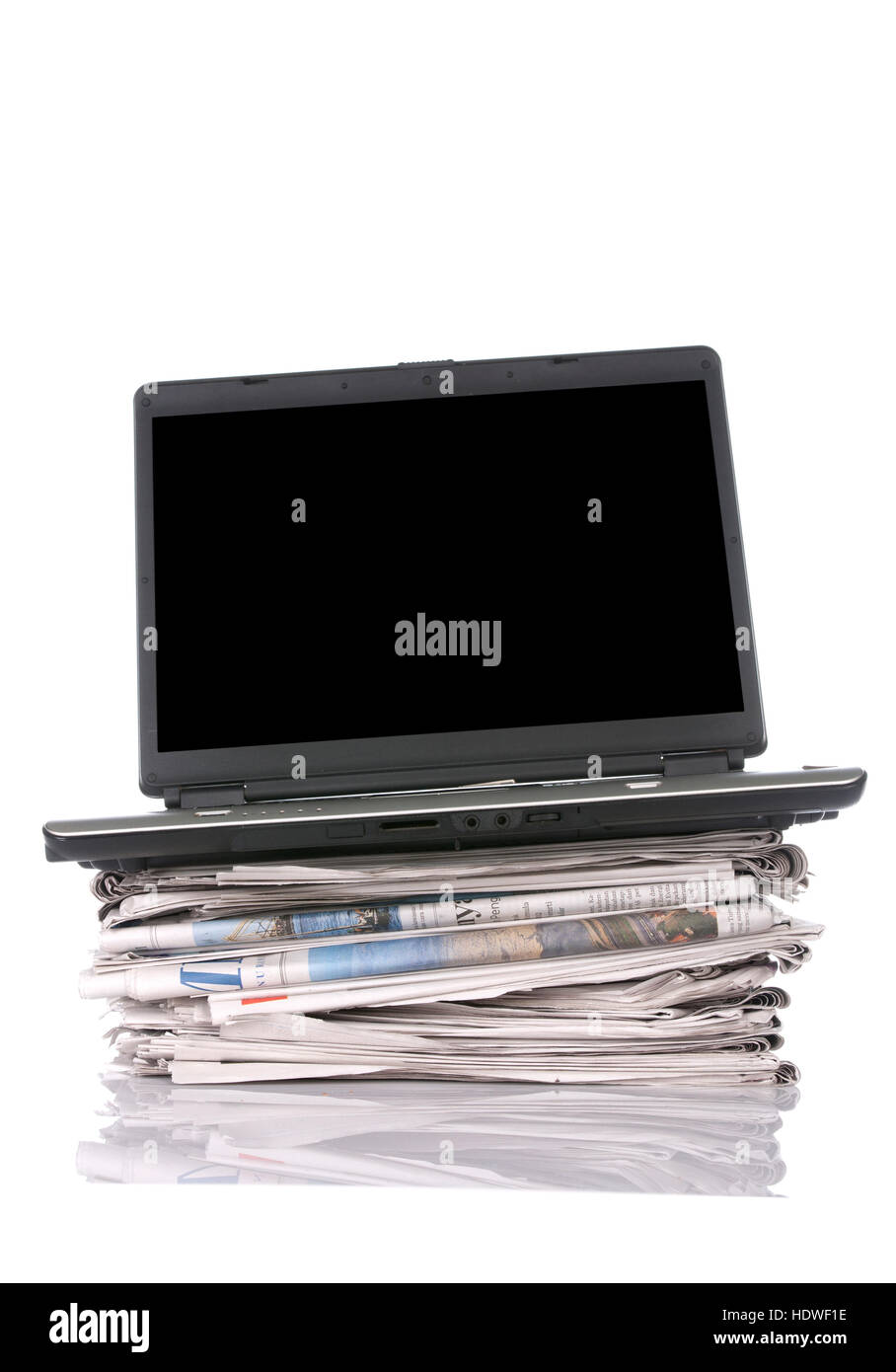 Black laptop with stacking newspaper isolated on white background. You ...