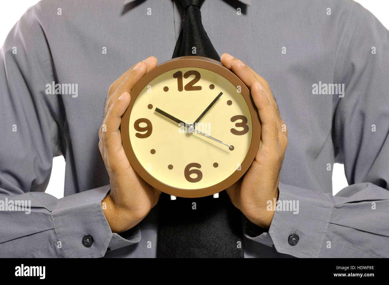 Businessman holding clock in his hand isolated over white background ...