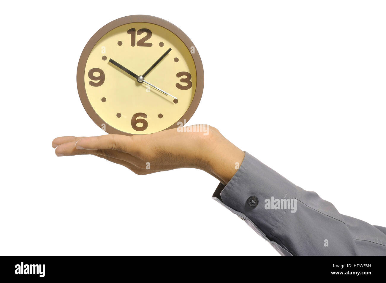 Hand holding clock isolated over white background. Overtime concept ...
