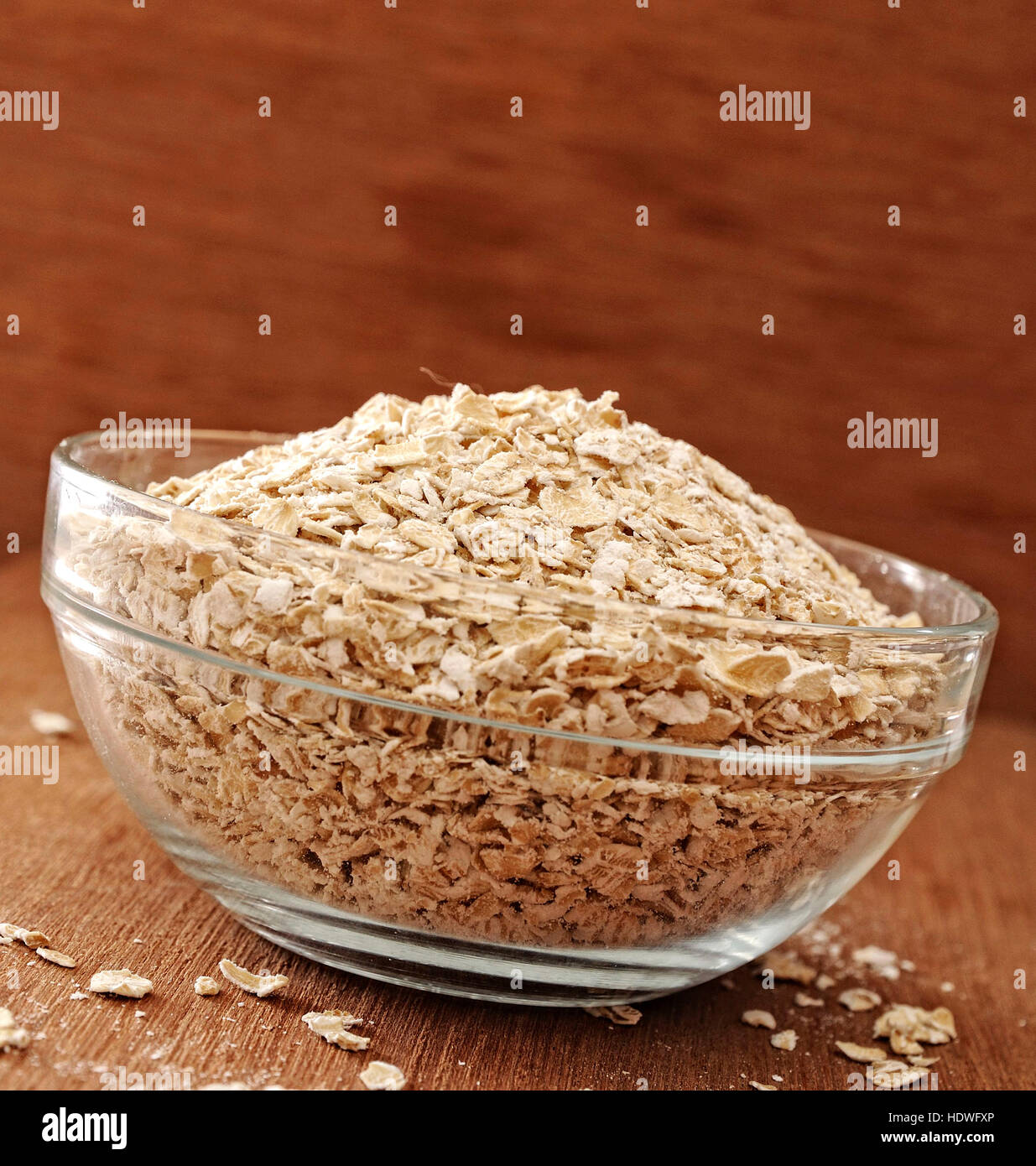 Oatmeal in glass bowl. Shot with wooden background Stock Photo - Alamy