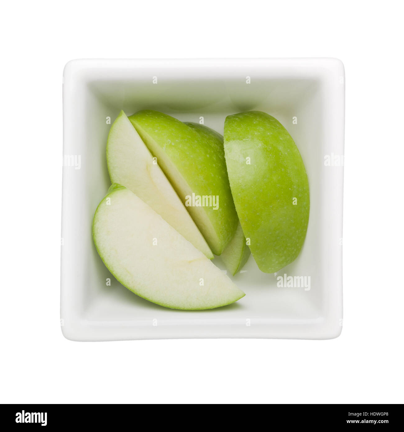 Slices of green apple in a square bowl isolated on white background ...