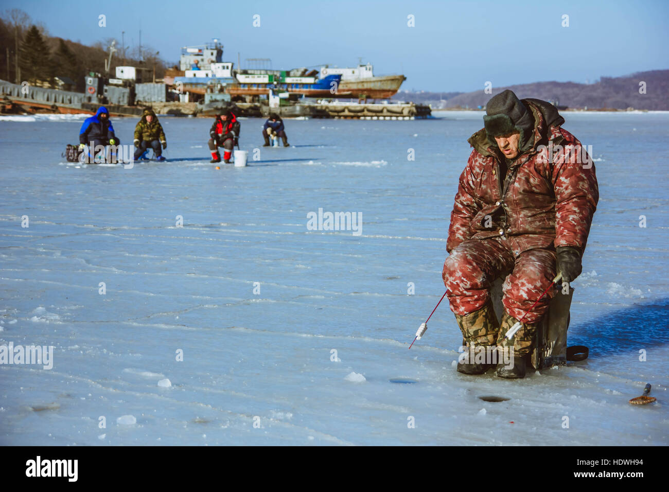 fisherman catches fish in the winter Russia Vladivostok Russian island ...