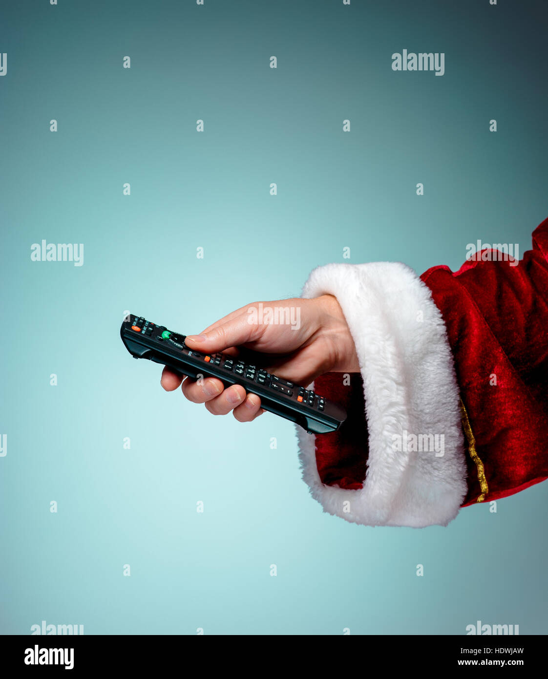 Santa Claus holding tv remote control on blue background Stock Photo ...