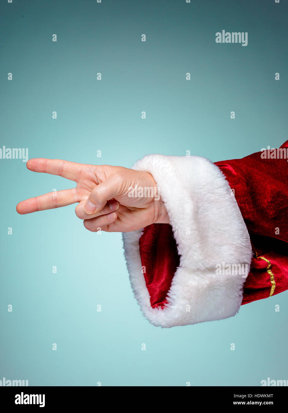 Santa Claus hand showing sign victory by thumbs up on blue background ...