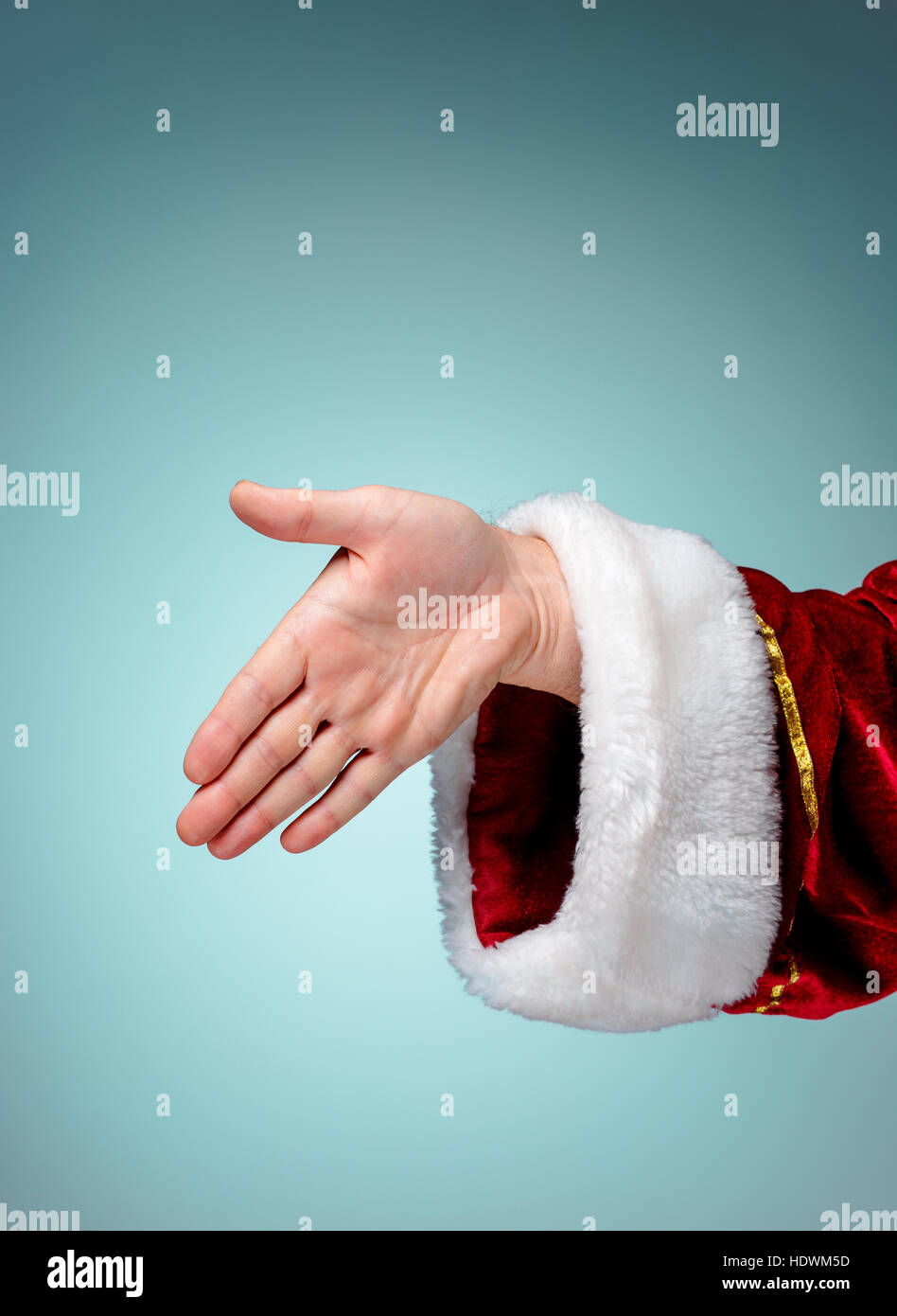 Photo of Santa Claus hand in gesture of a handshake on blue Stock Photo ...