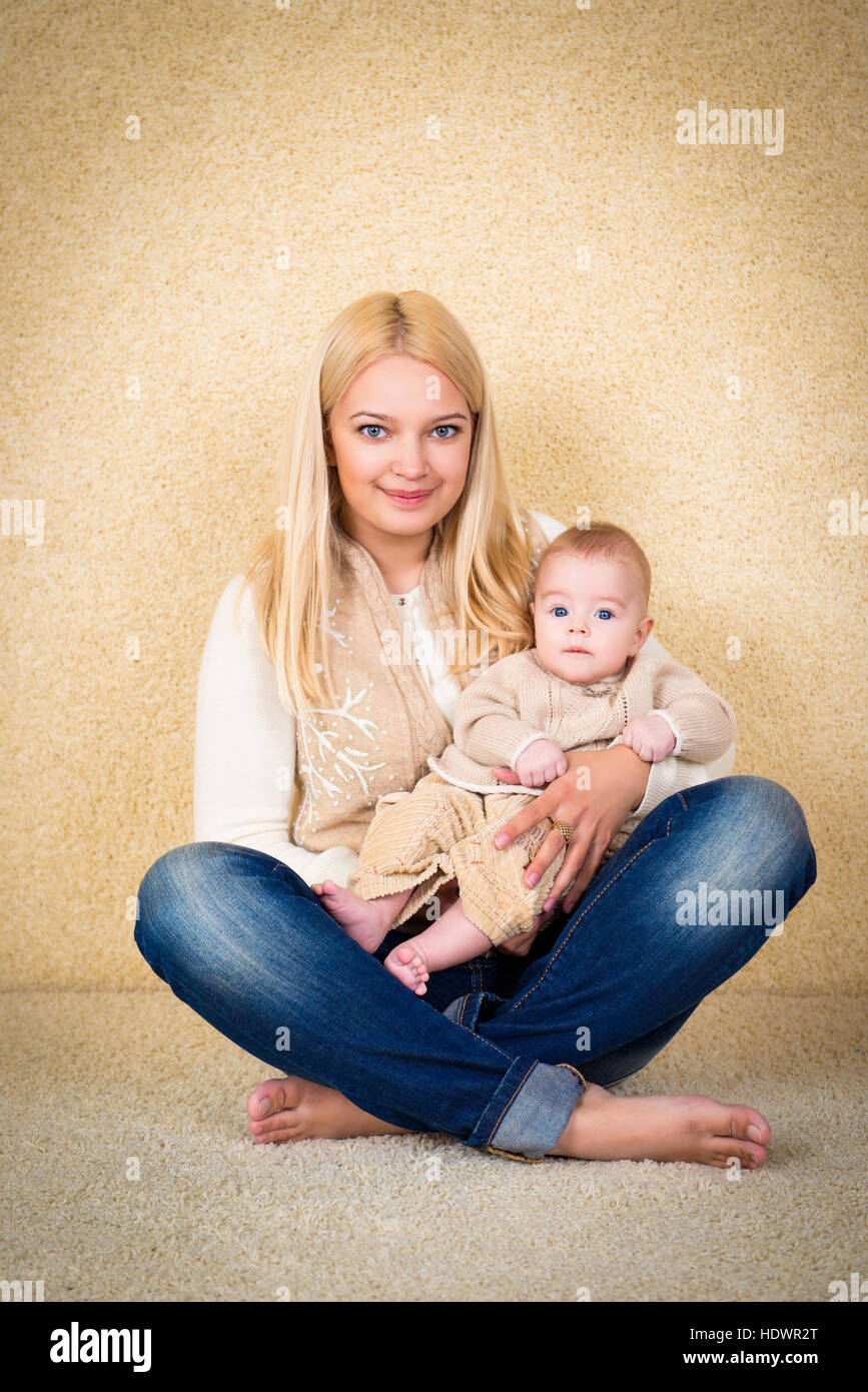 Happy family on beige background. Young parents Stock Photo - Alamy