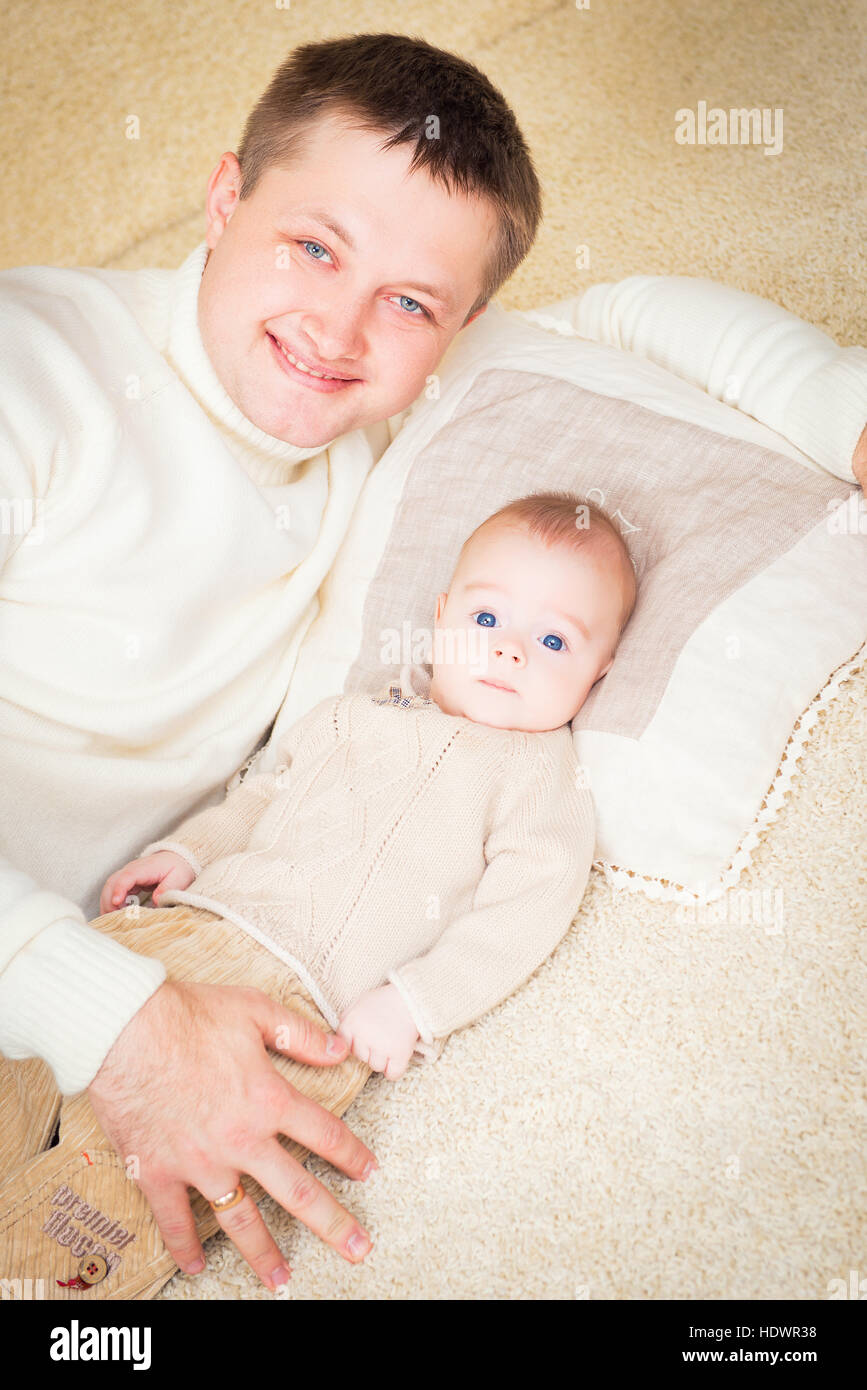 Happy family on beige background. Young parents Stock Photo - Alamy