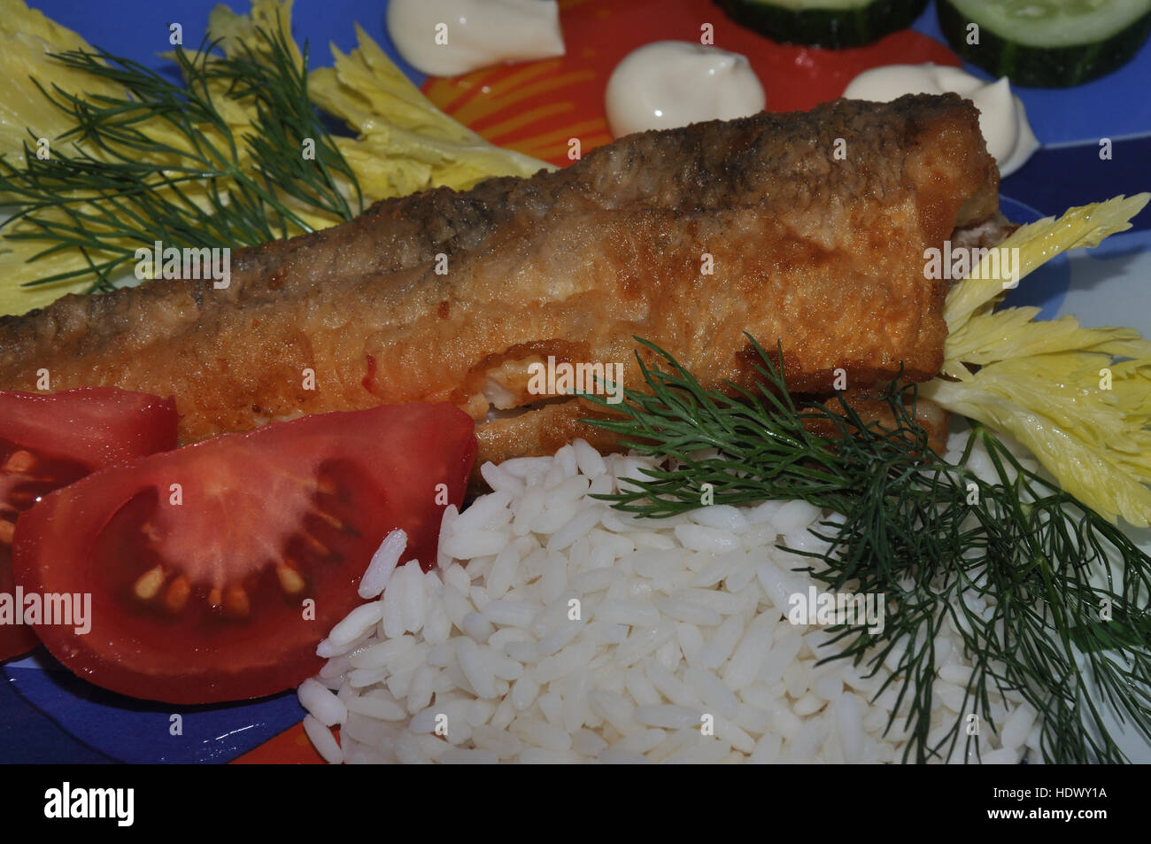 Fried fish with rice and fresh herbs Stock Photo - Alamy