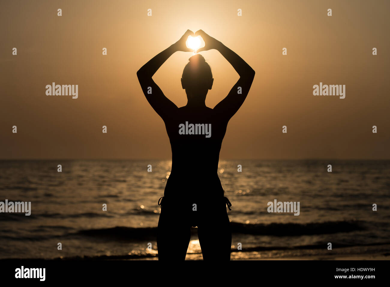 Beautiful Female Model Enjoying Sunset and Making Heart Sign on Sun at ...