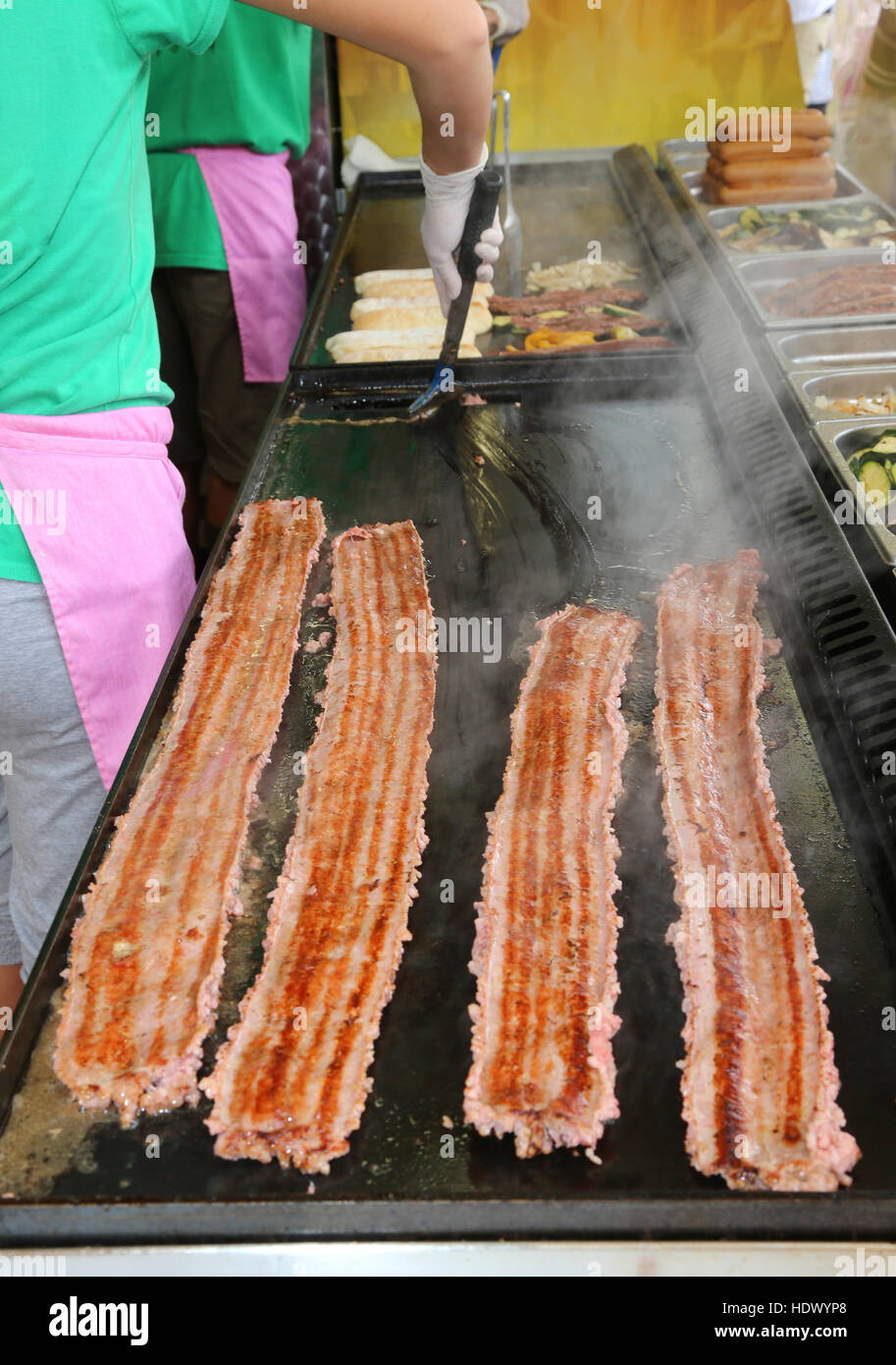 long strip of meat cooked on the hot plate in the stand that prepares ...