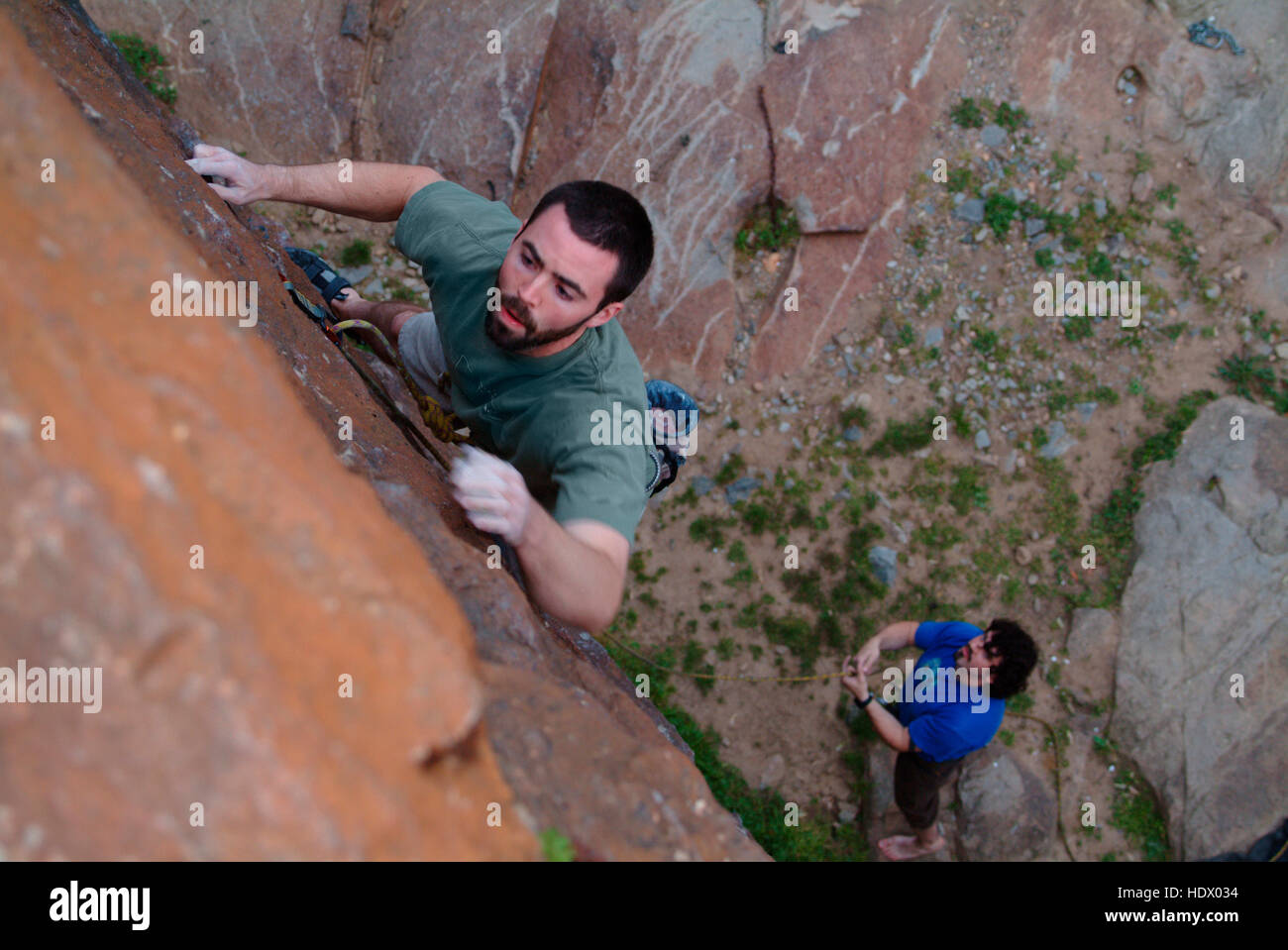 Spotter watching friend climbing urban brick wall Stock Photo - Alamy