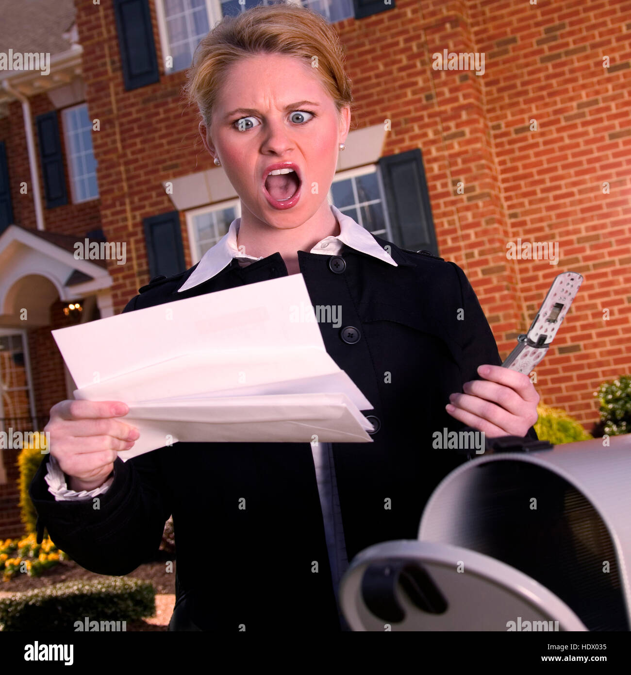 Angry woman reading mail at mailbox Stock Photo - Alamy