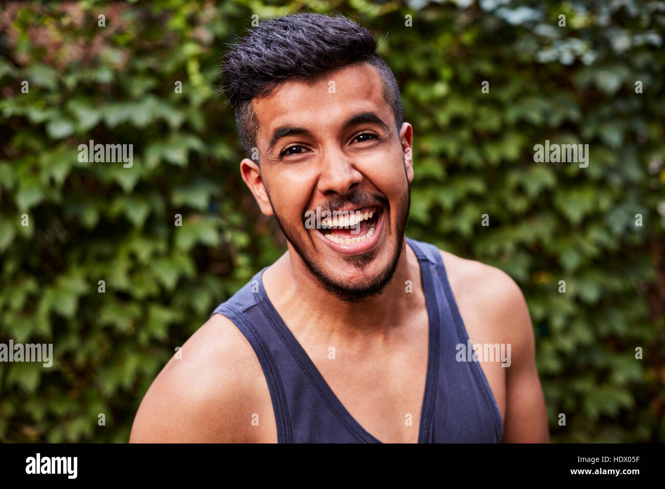 Laughing Middle Eastern man wearing tank-top Stock Photo - Alamy