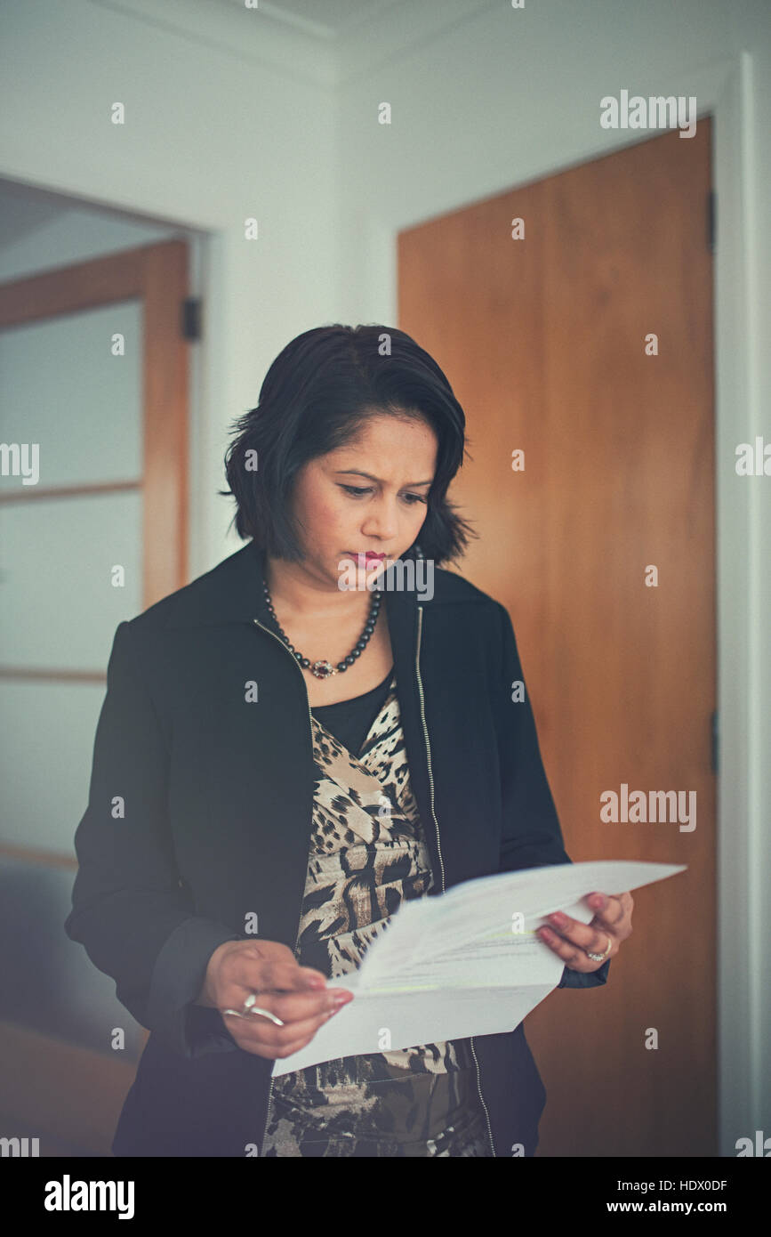 Indian woman reading paperwork Stock Photo - Alamy