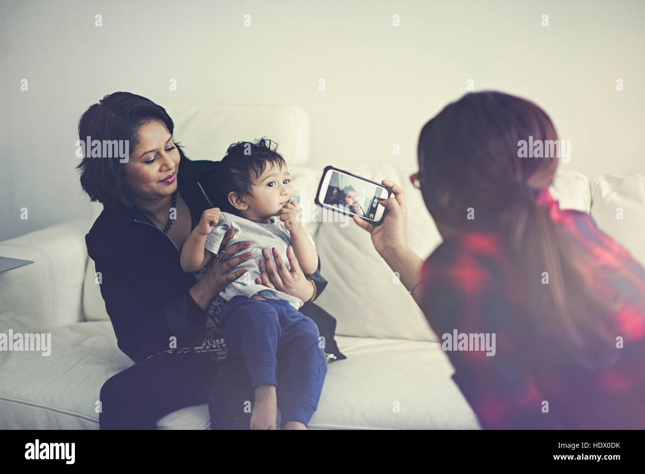 Indian woman photographing mother and son with cell phone Stock Photo ...