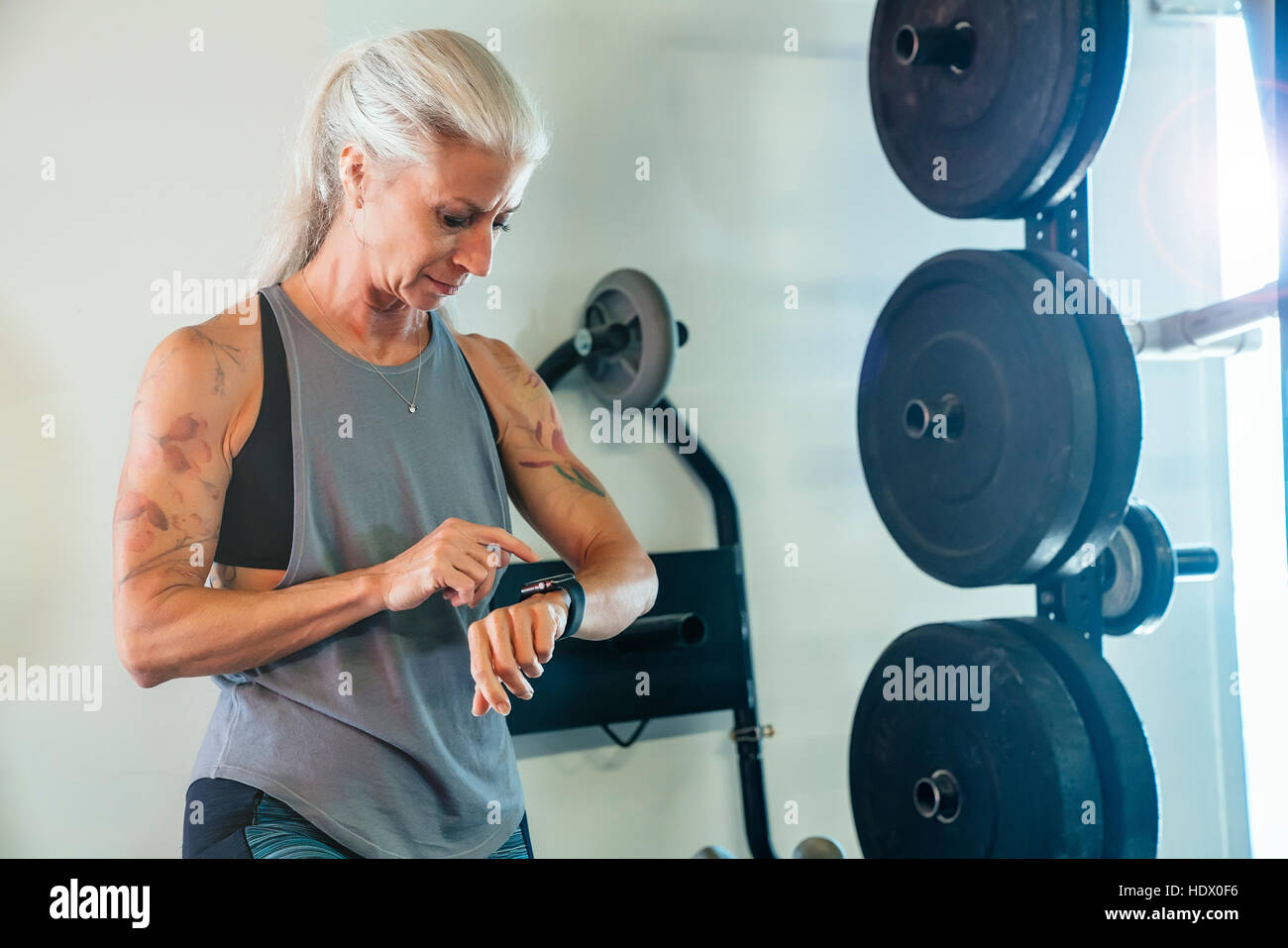 Caucasian woman tapping smart watch in gymnasium Stock Photo - Alamy