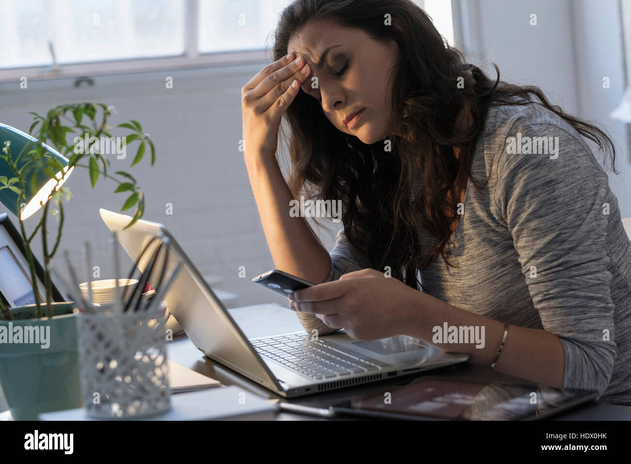 Hispanic businesswoman using technology in office Stock Photo - Alamy