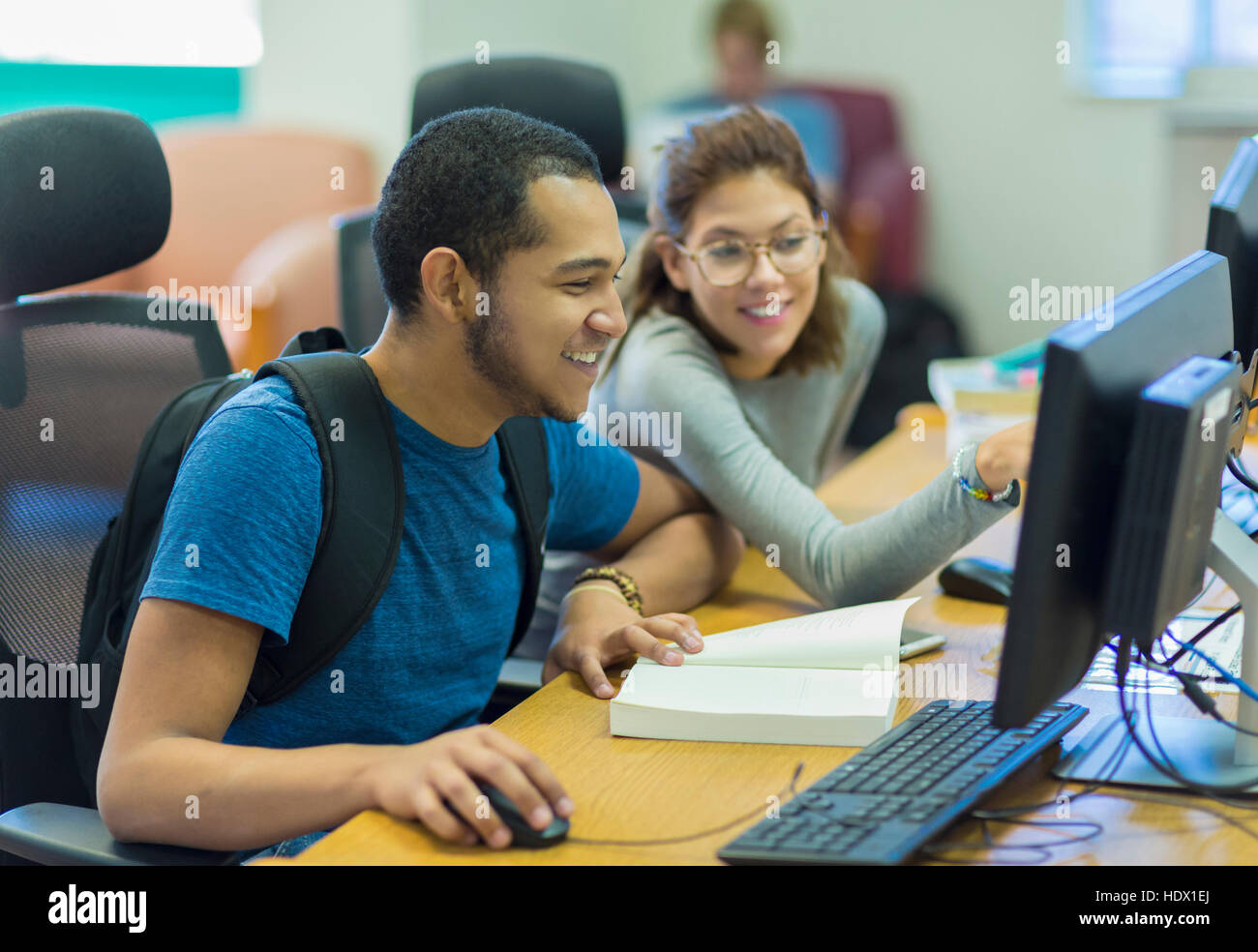 Mixed Race boy and girl using computer in library Stock Photo - Alamy