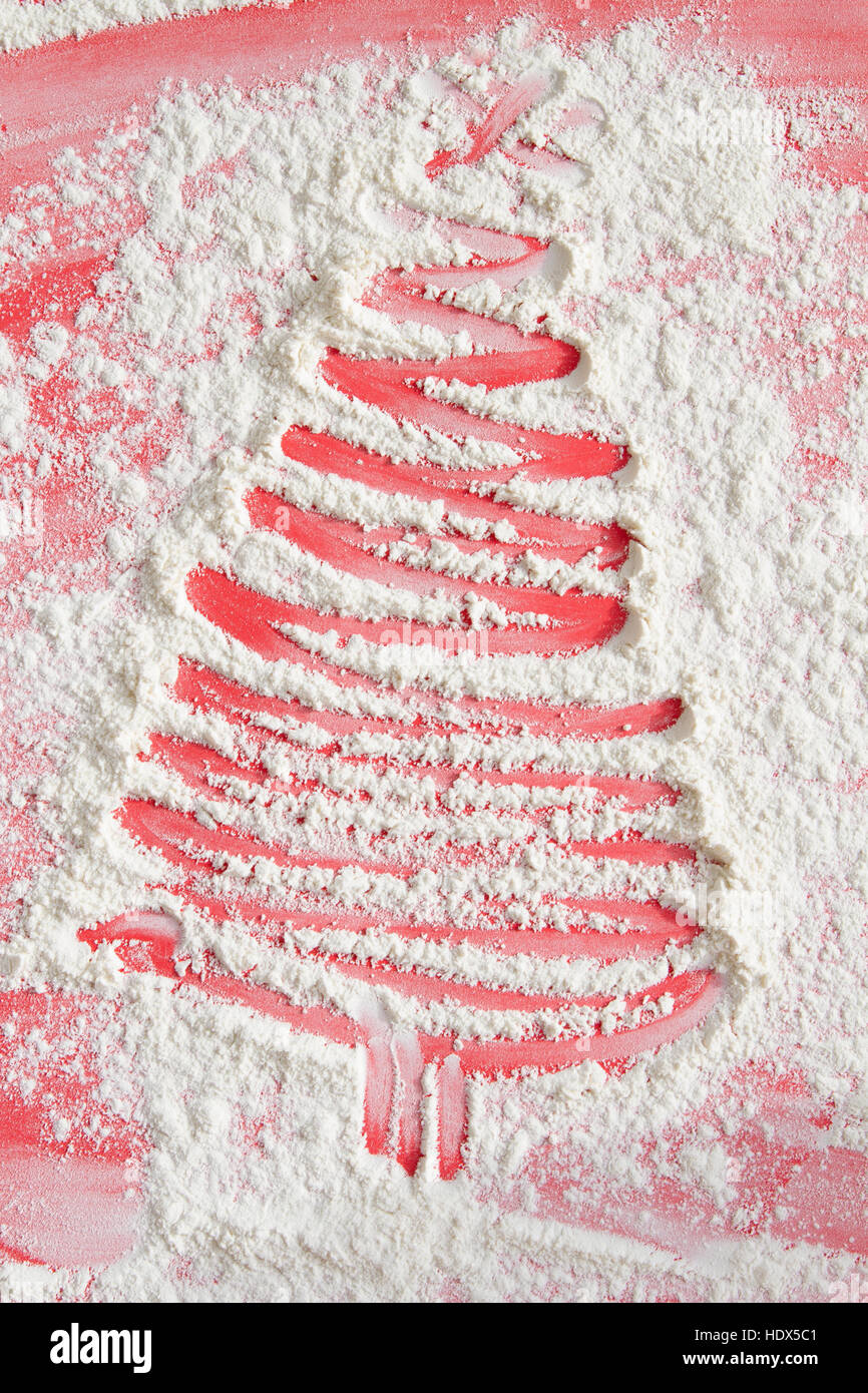 Christmas tree on flour background. White flour looks like snow. Top ...
