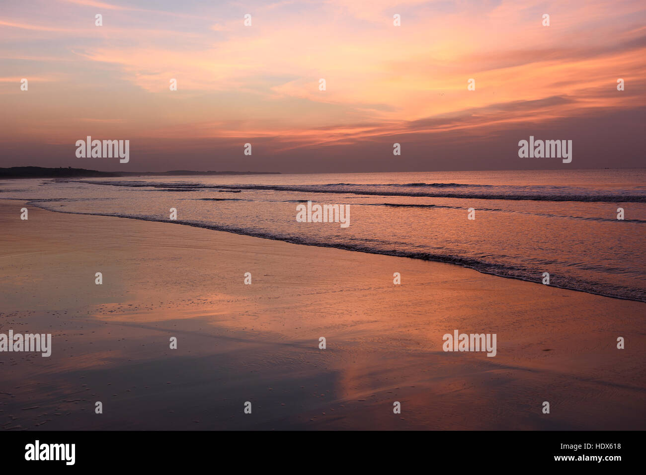 Sunrise at a beach with dramatic colorful clouds, sea, sand, reflection ...