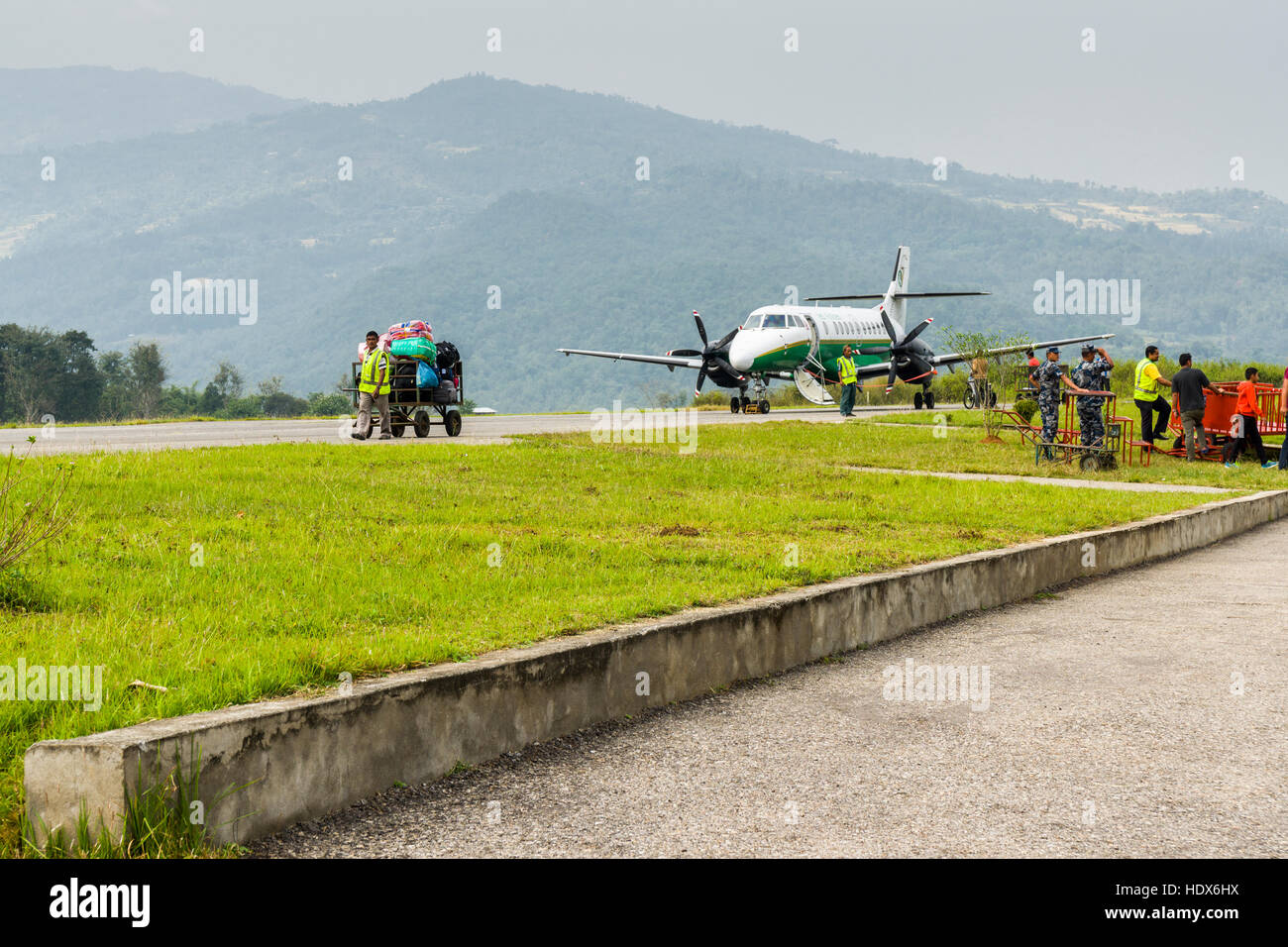 A worker is transporting luggage at the airport of Tumlingtar Stock ...