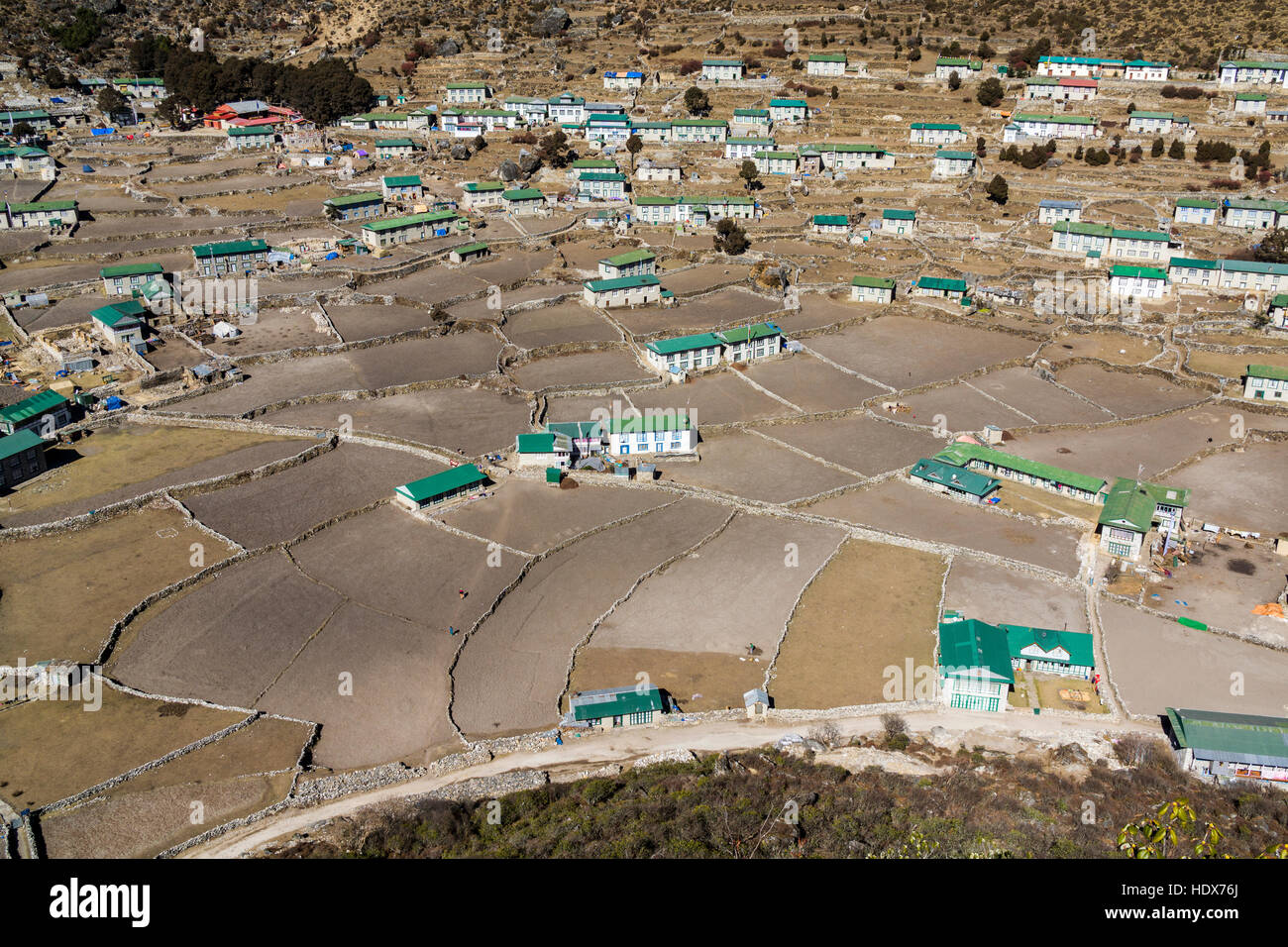 The agricultural village with fields and farmers houses is spread out ...