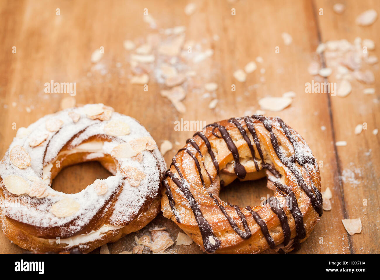 Chocolate and powdered sugar cream puff rings (choux pastry), black and ...