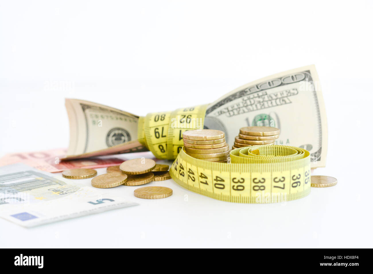 Dollar bills tied up with measuring tape suggesting measuring the ...