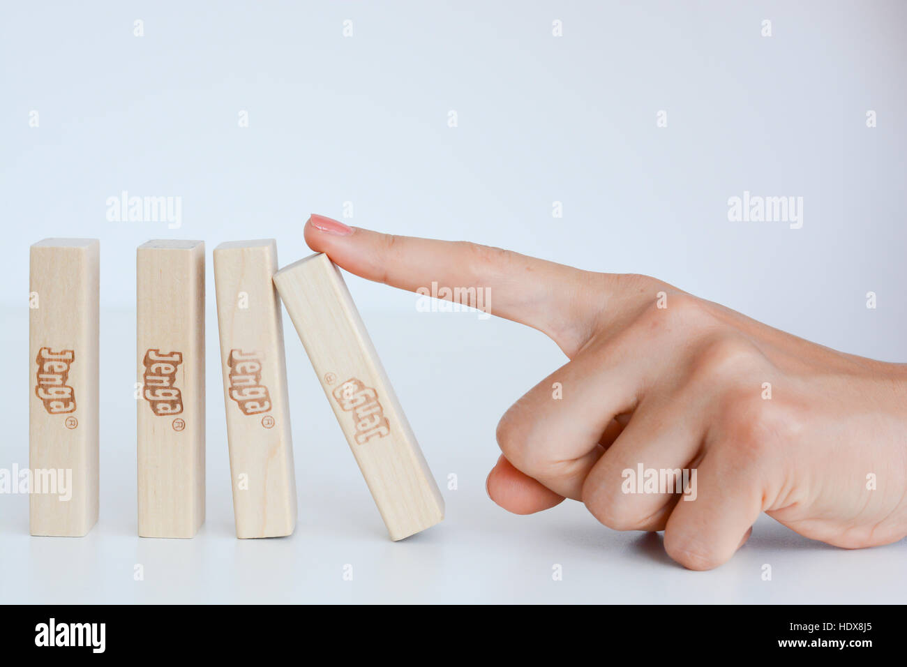 Human hand starting a domino effect concept with wooden blocks Stock ...