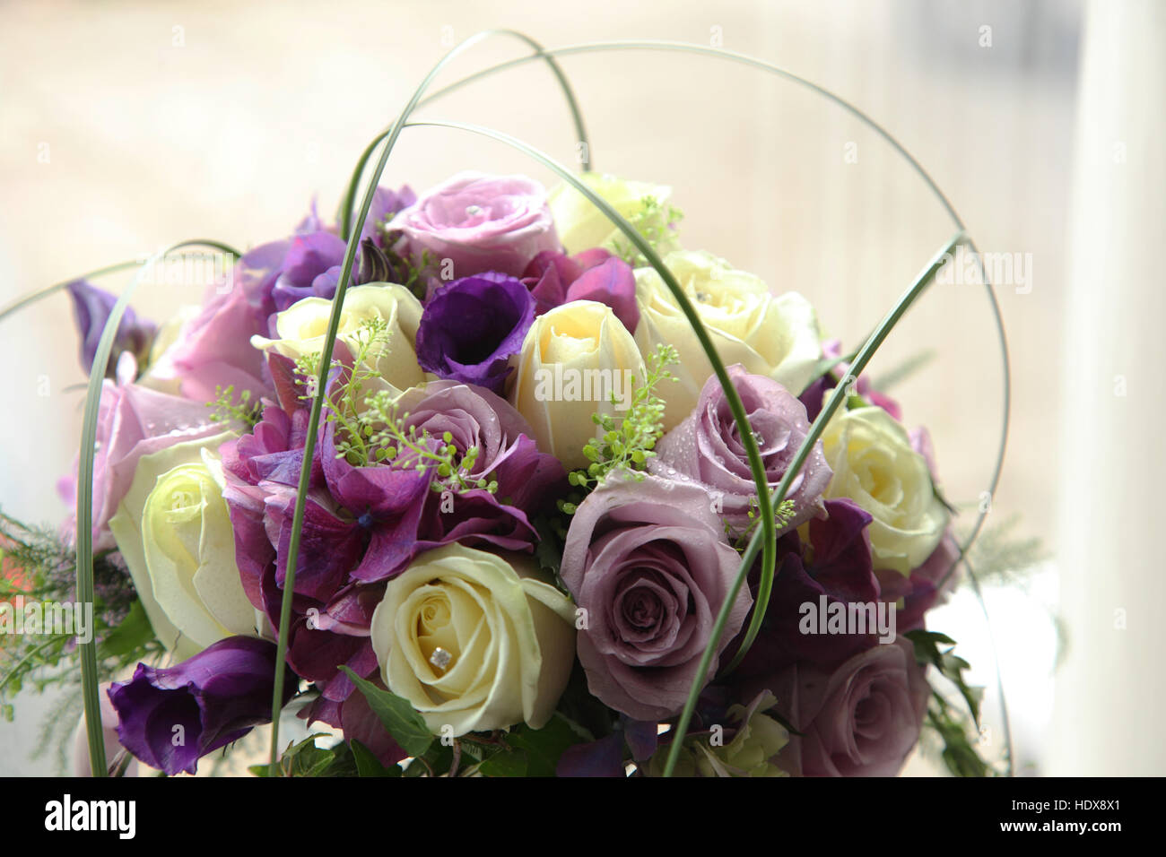 A wedding bouquet made of roses in dusky pink, magenta, and cream ...