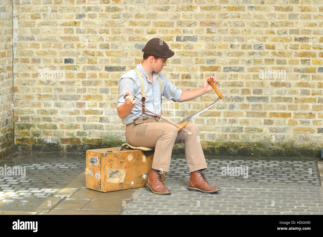 Young man playing the saw on the South Bank London Stock Photo - Alamy