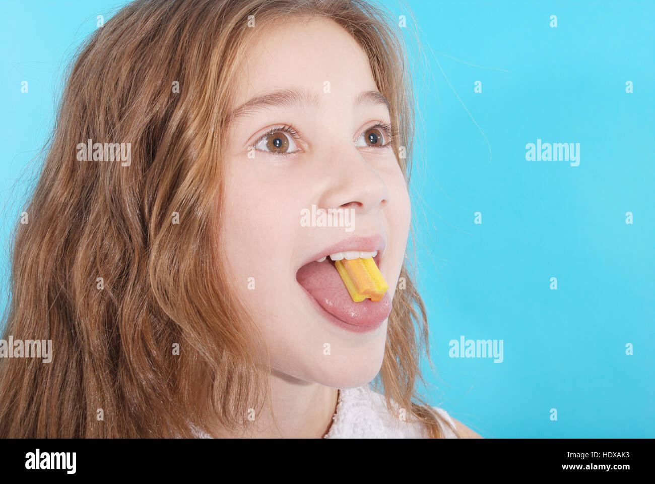 Close up on a beautiful girl while enjoying a chewing gum on blue Stock ...