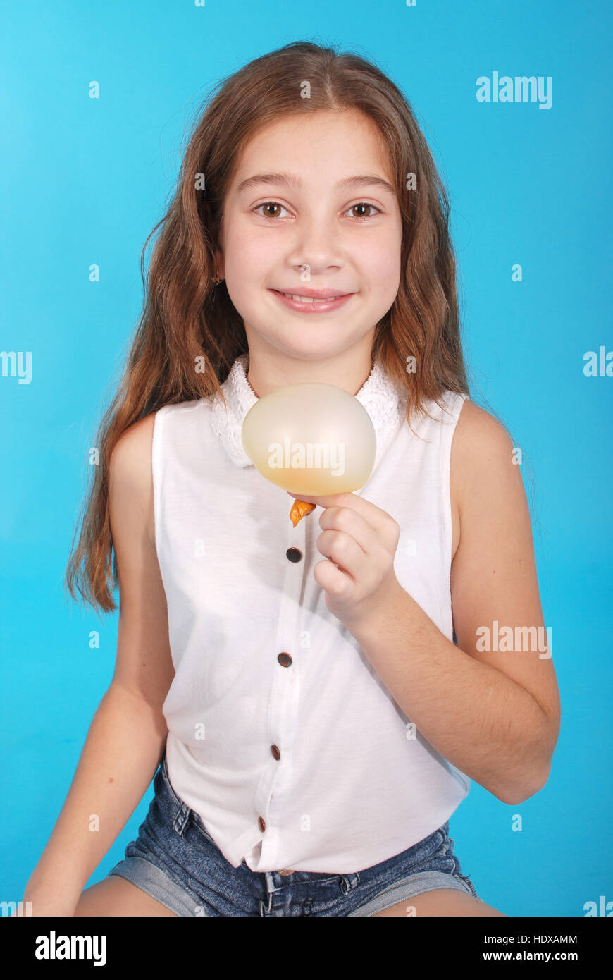 Young girl playing with chewing gum isolated on blue Stock Photo - Alamy
