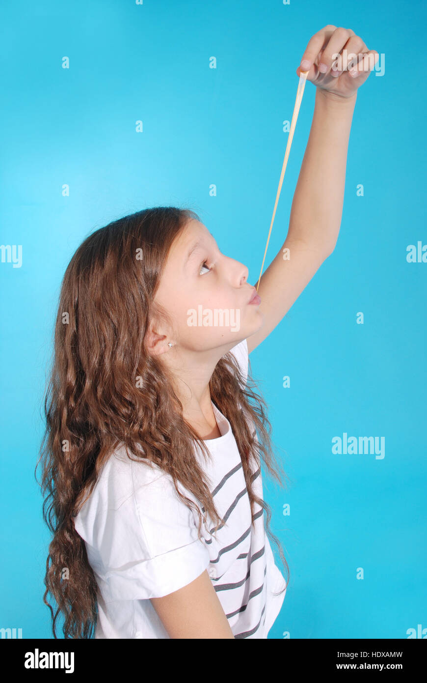 Young girl playing with chewing gum isolated on blue Stock Photo - Alamy