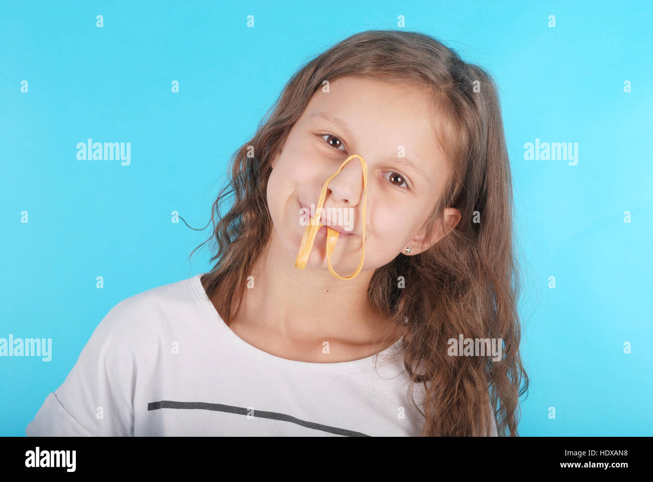 Young girl playing with chewing gum isolated on blue Stock Photo - Alamy