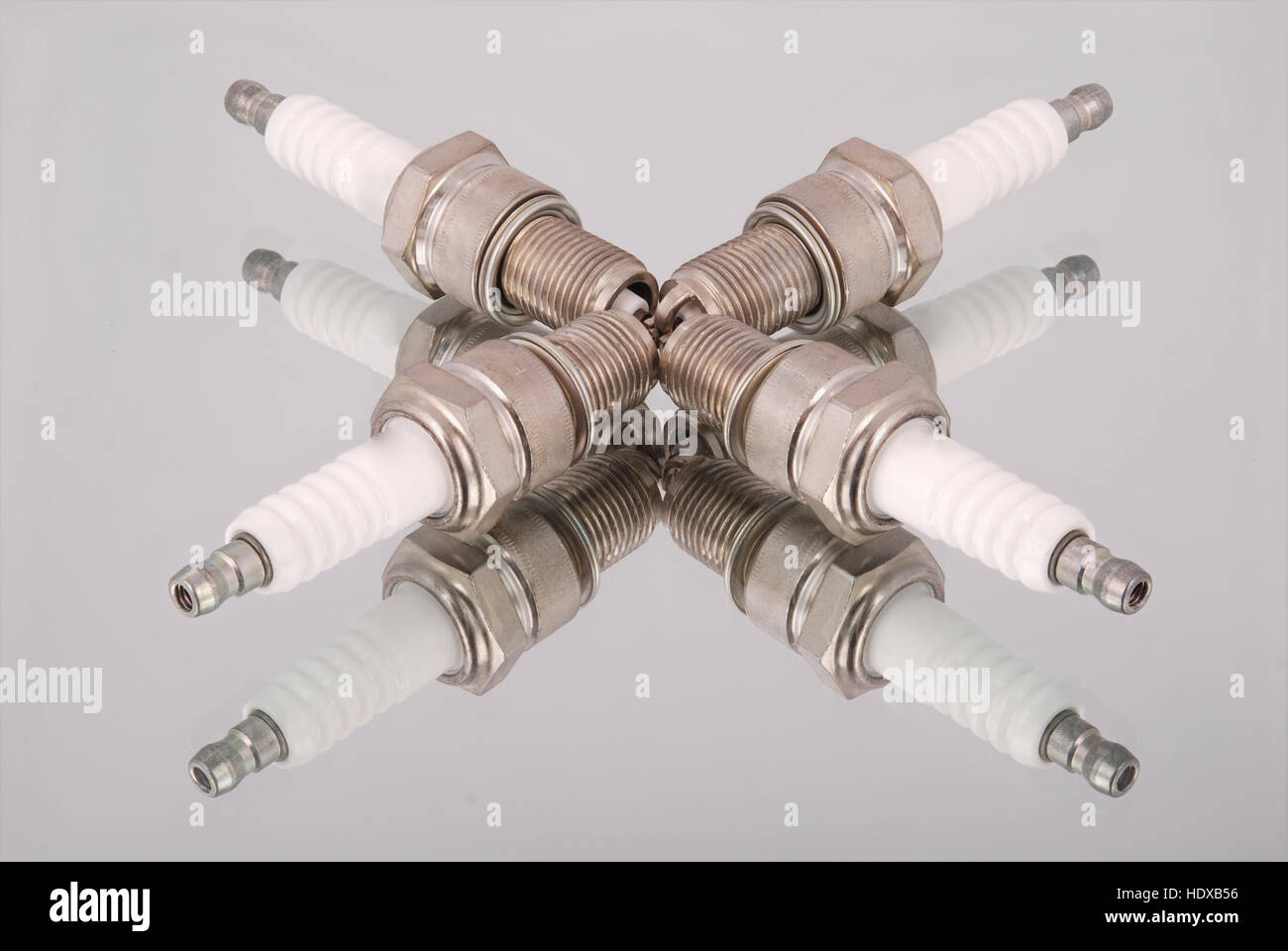 Four new spark plugs on a mirror background Stock Photo - Alamy
