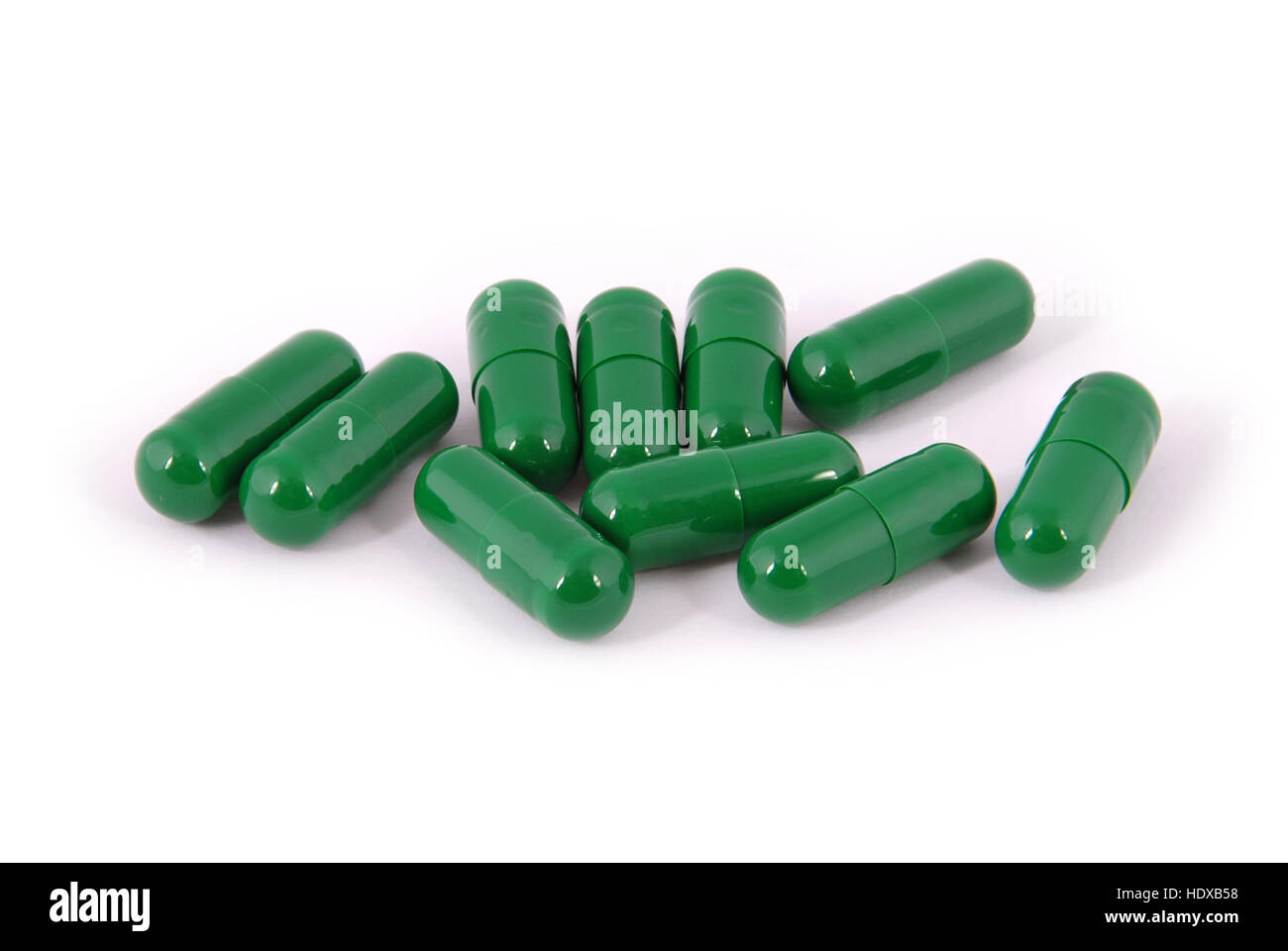 Group of capsule pills with green color on white background with soft ...