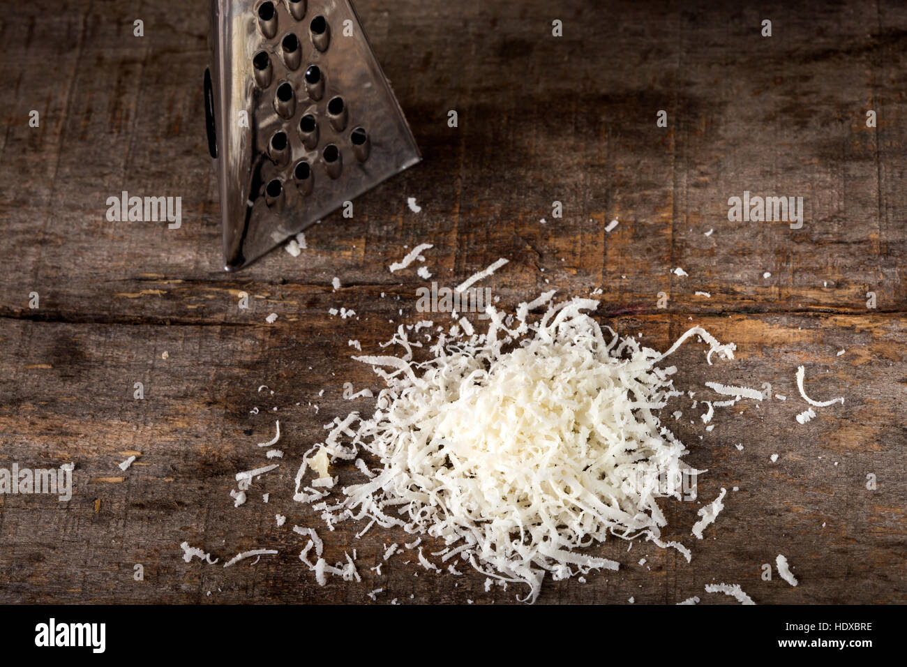 Freshly grated parmesan cheese on wooden table Stock Photo - Alamy