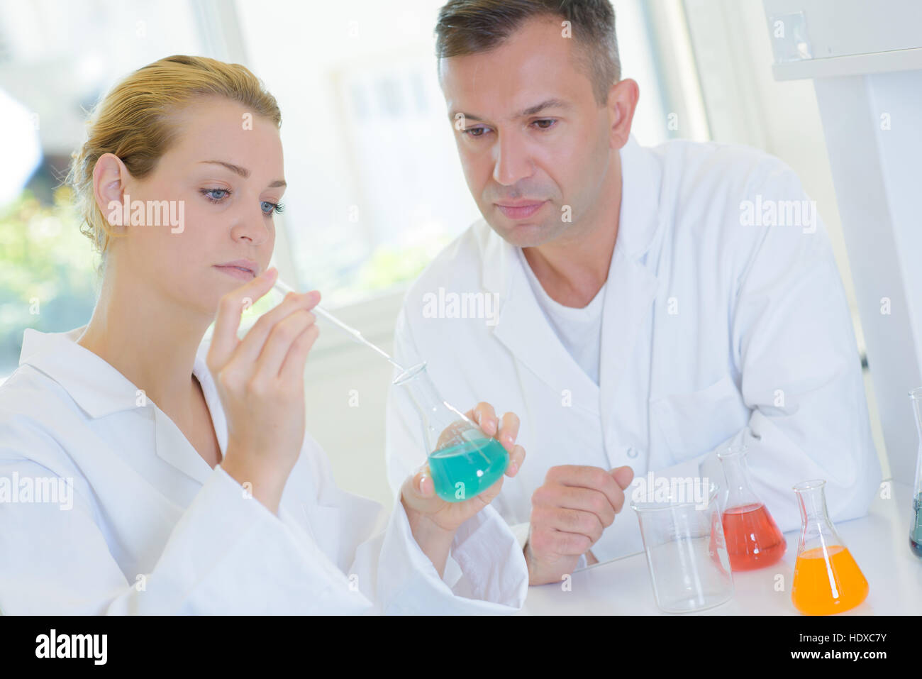 Man and woman performing experiment in laboratory Stock Photo - Alamy