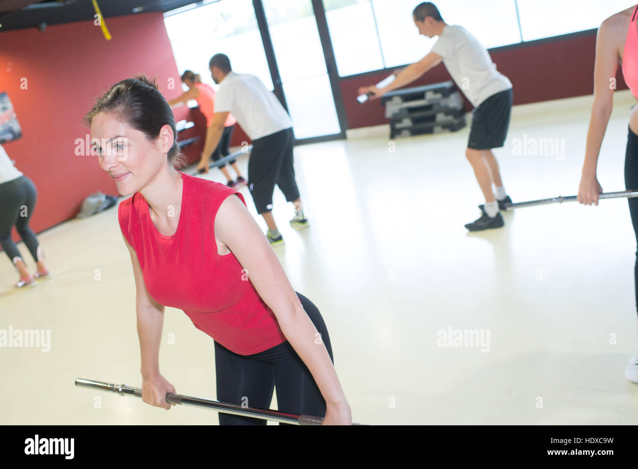 Woman in exercise class using metal bar Stock Photo - Alamy