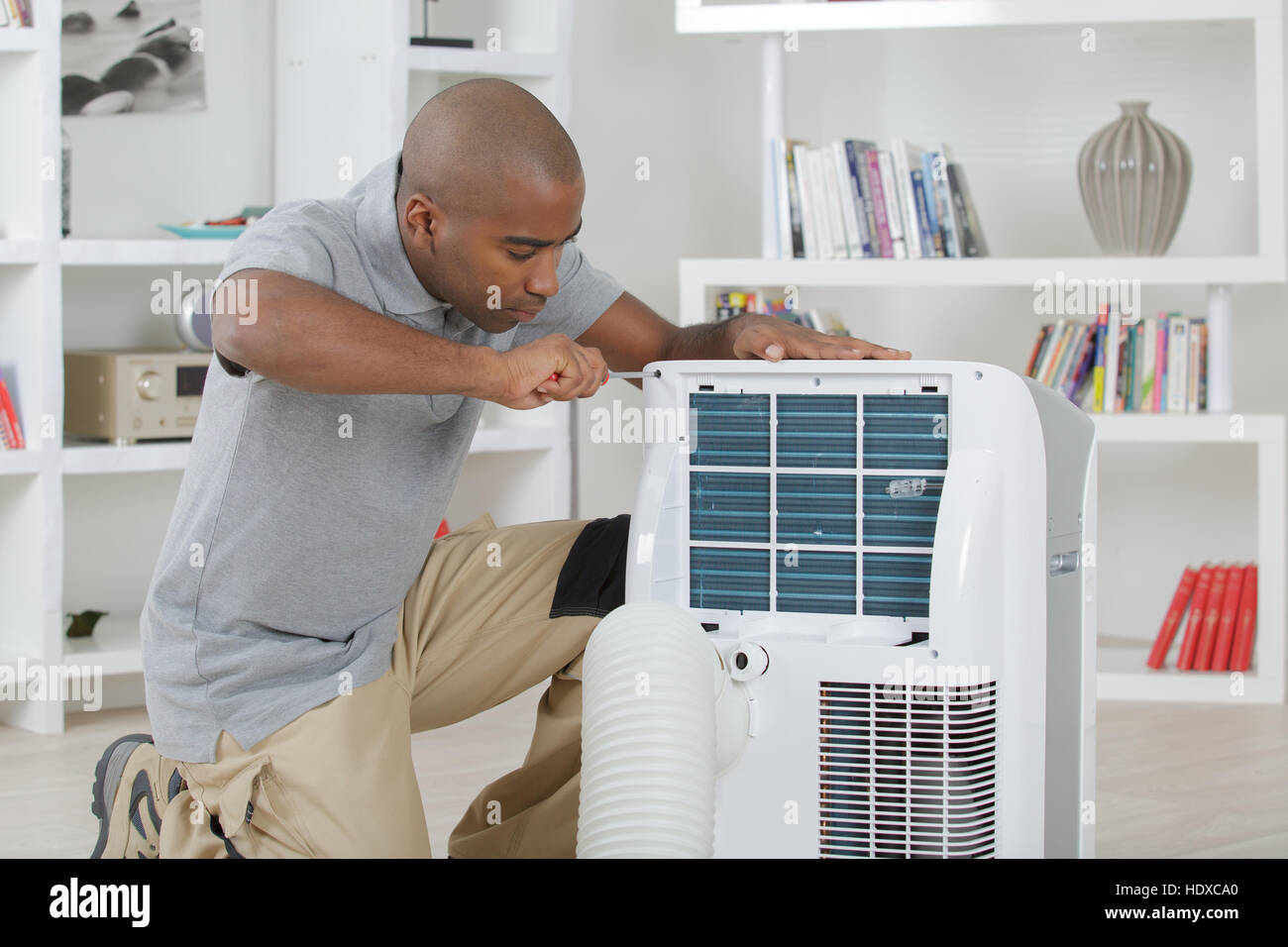 Man working on air conditioning unit Stock Photo - Alamy