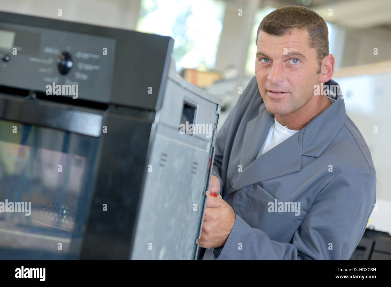 Repairman working on an oven Stock Photo - Alamy