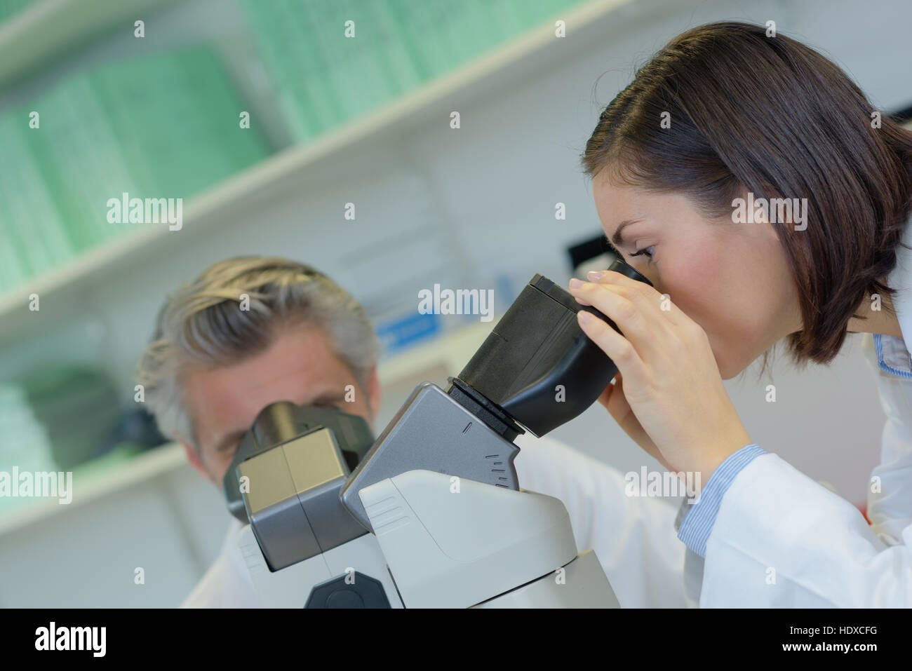 Woman looking into microscope eyepiece hi-res stock photography and ...