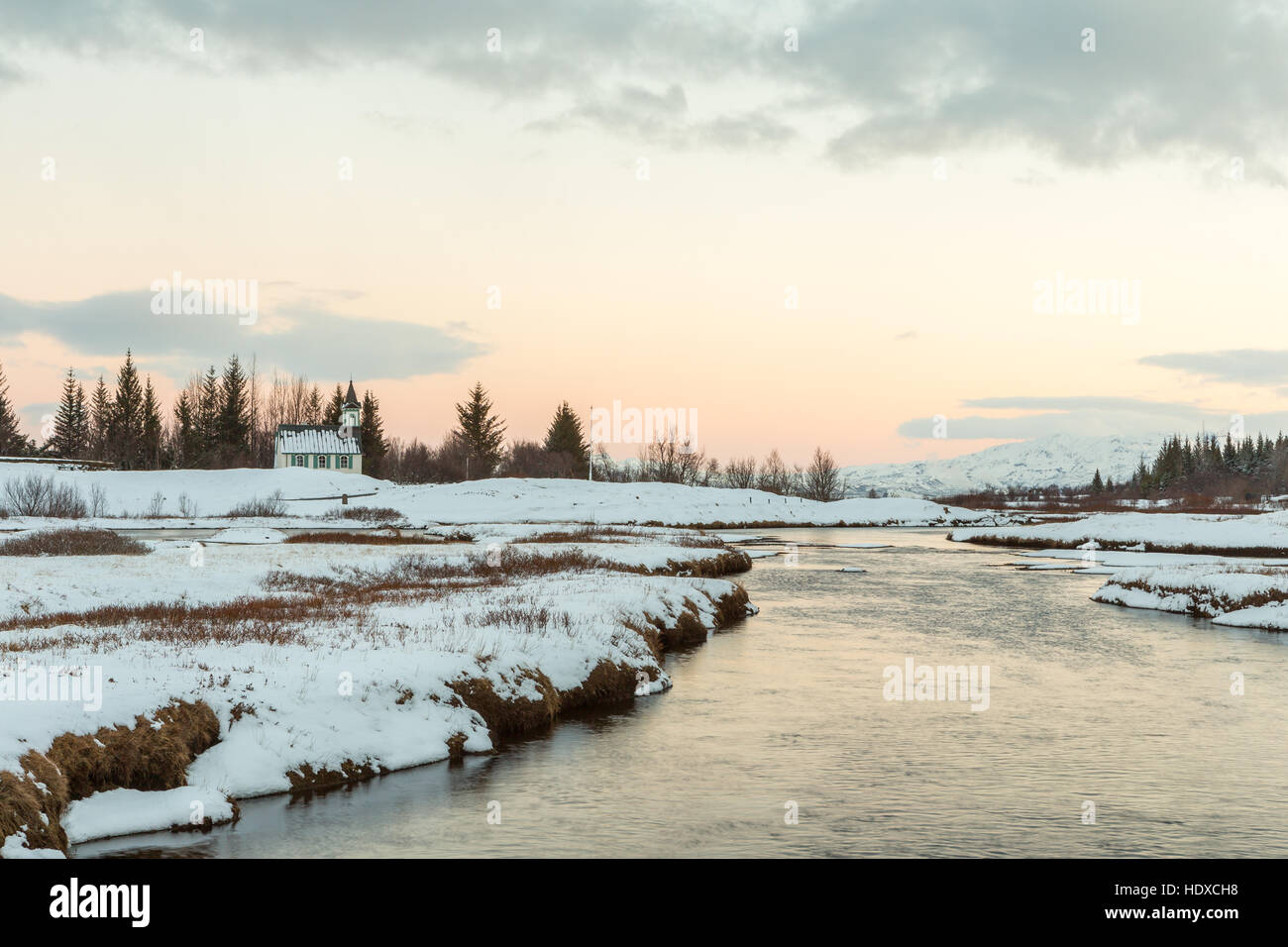 The Thingvellir church in a lagoon of melting snow and streams ...