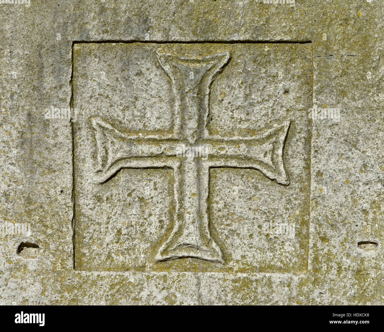 Medieval holy cross carved on ancient stone block with lichen, in the ...