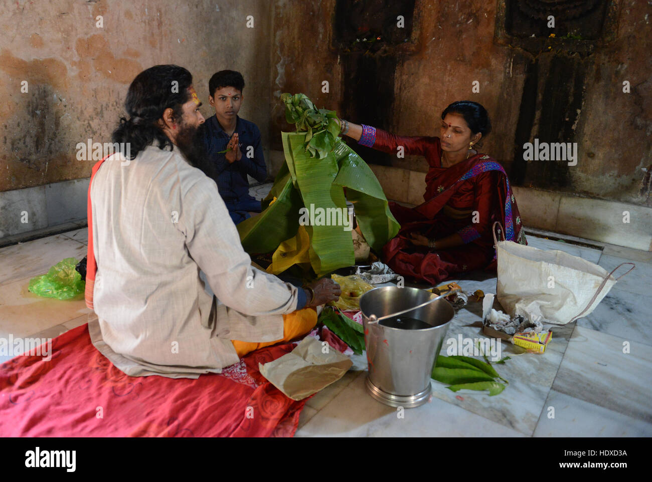 A Hindu priest performing puja inside the Shiva Dol temple in Sivasagar ...