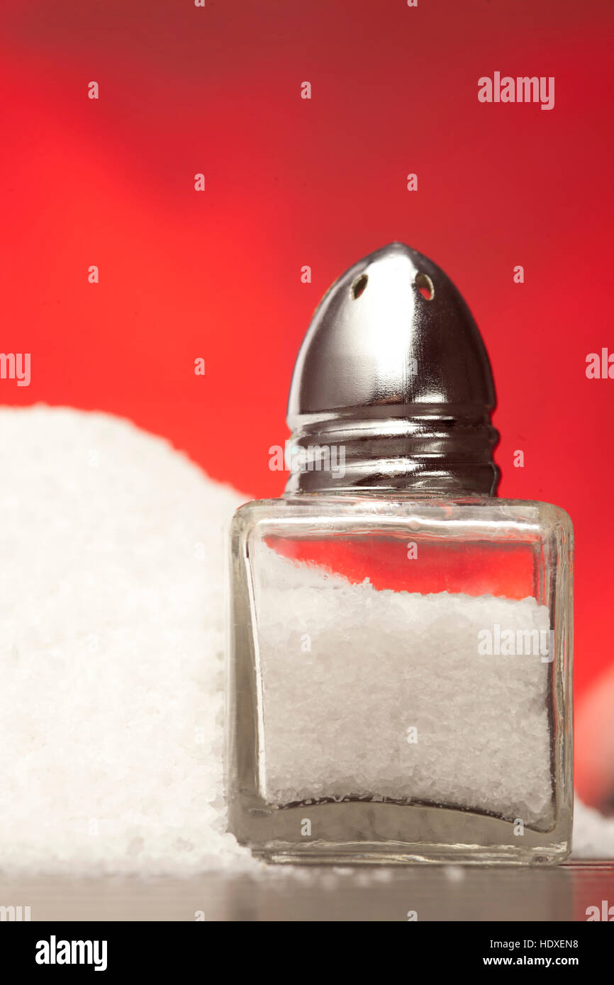 glass salt shaker on gray table and red background Stock Photo - Alamy