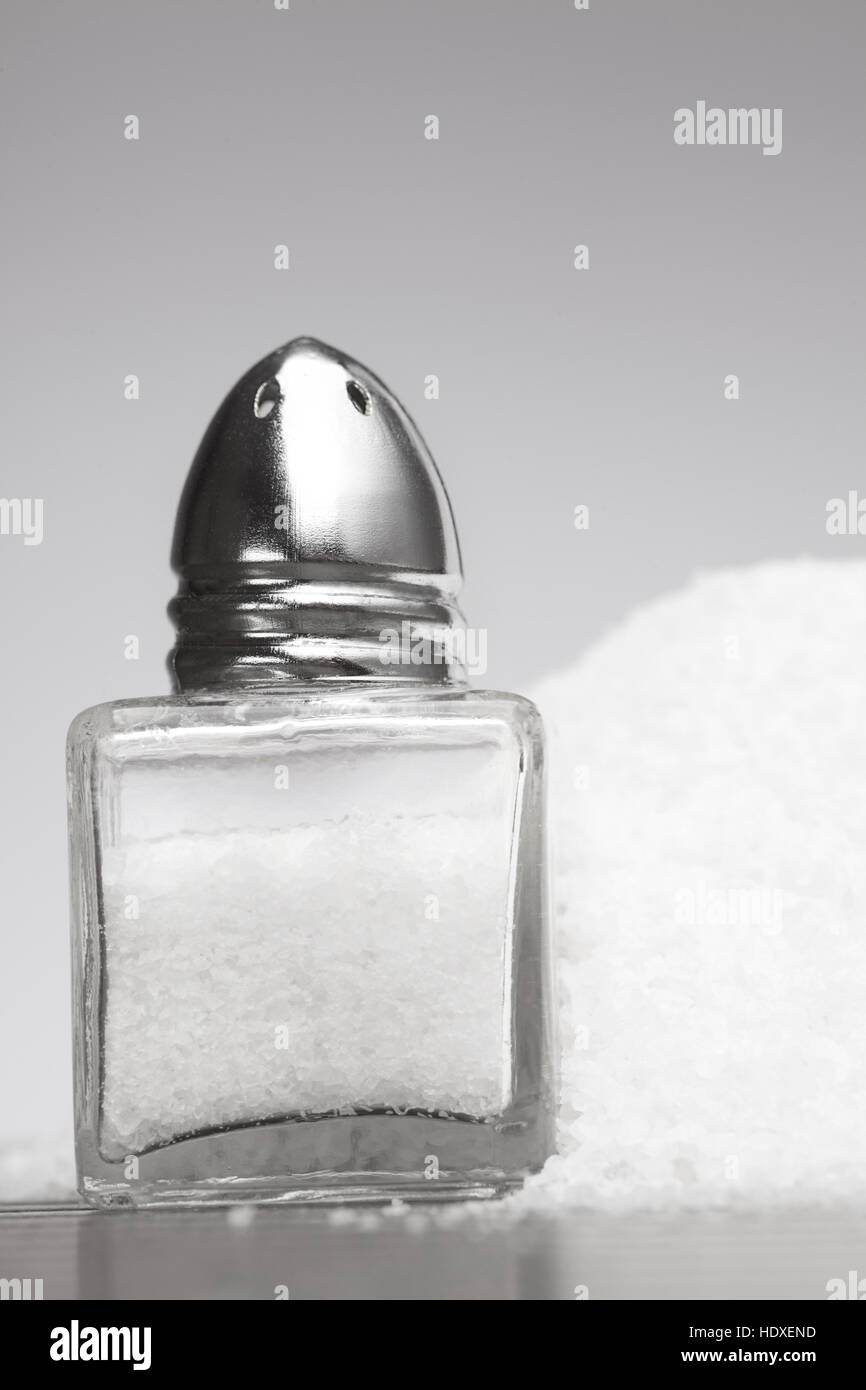 glass salt shaker on gray table and white background Stock Photo - Alamy