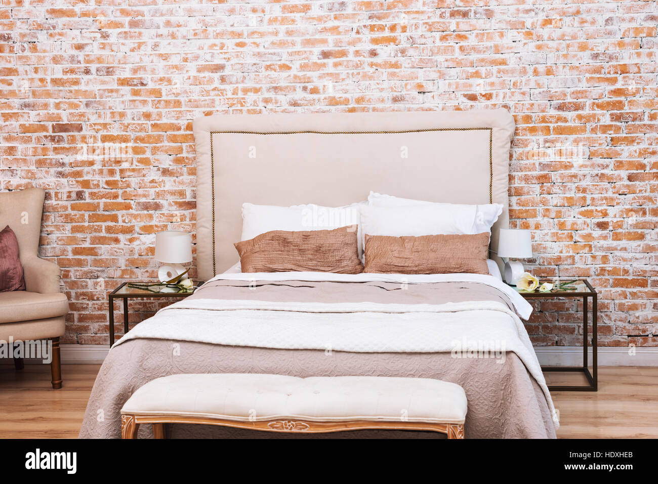 Beautiful loft bedroom with bed and armchair near brick wall Stock ...